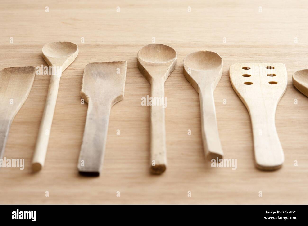 Set of different plain wooden kitchen spoons and spatulas laid out on a ...