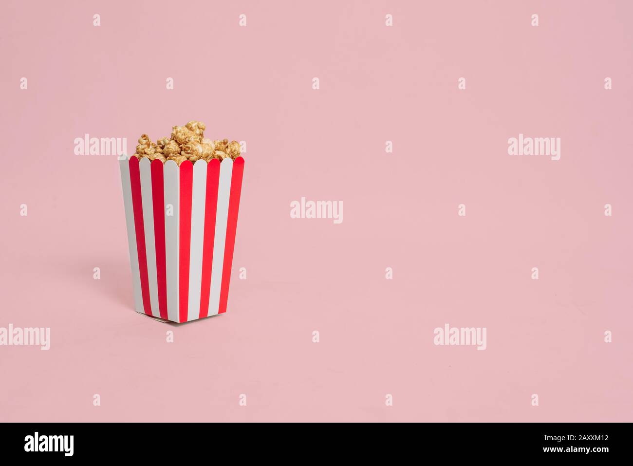 Movie Popcorn in striped bucket isolated on pink pastel background with ...