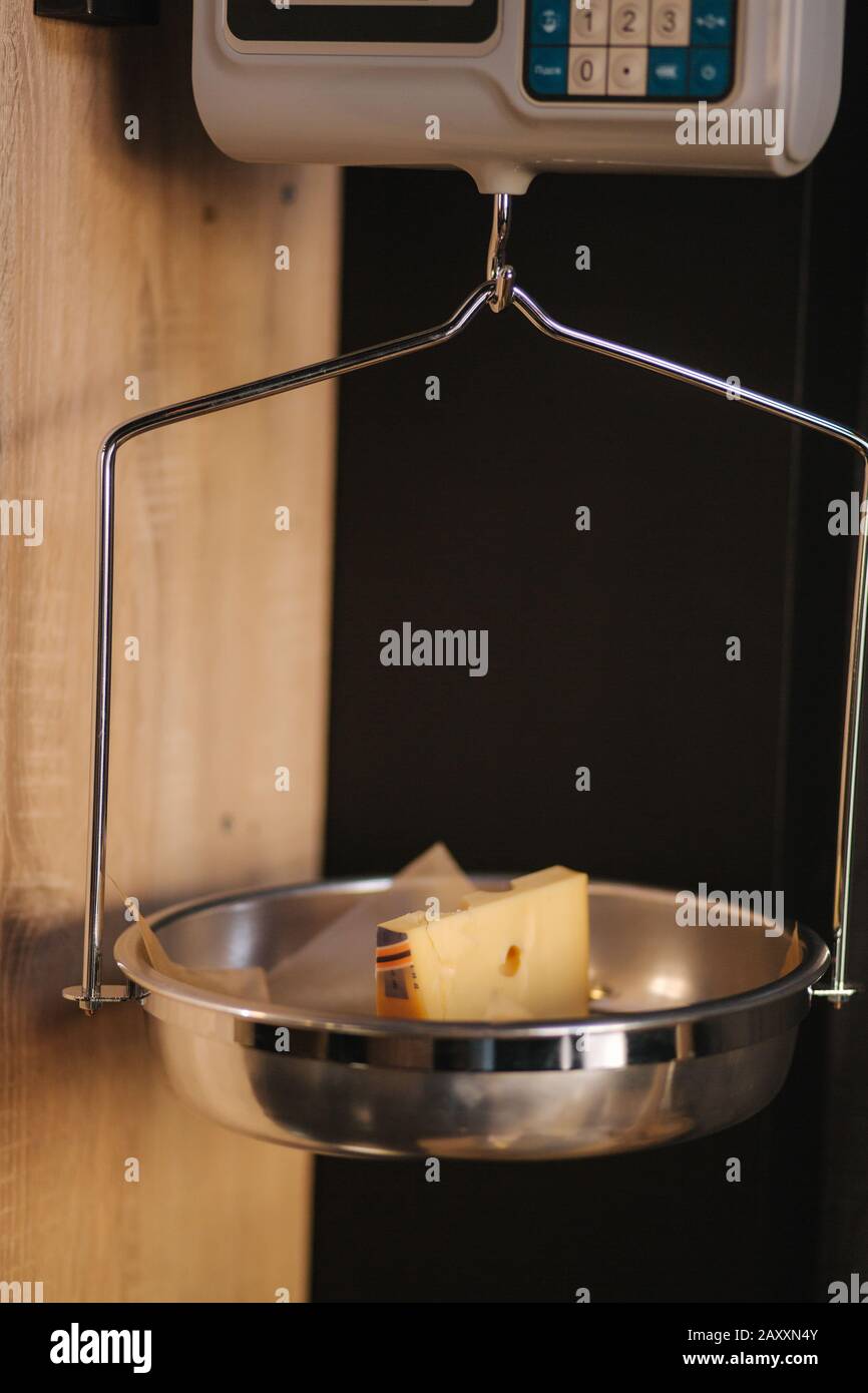 Slice of cheese weigh in cheese store Stock Photo - Alamy