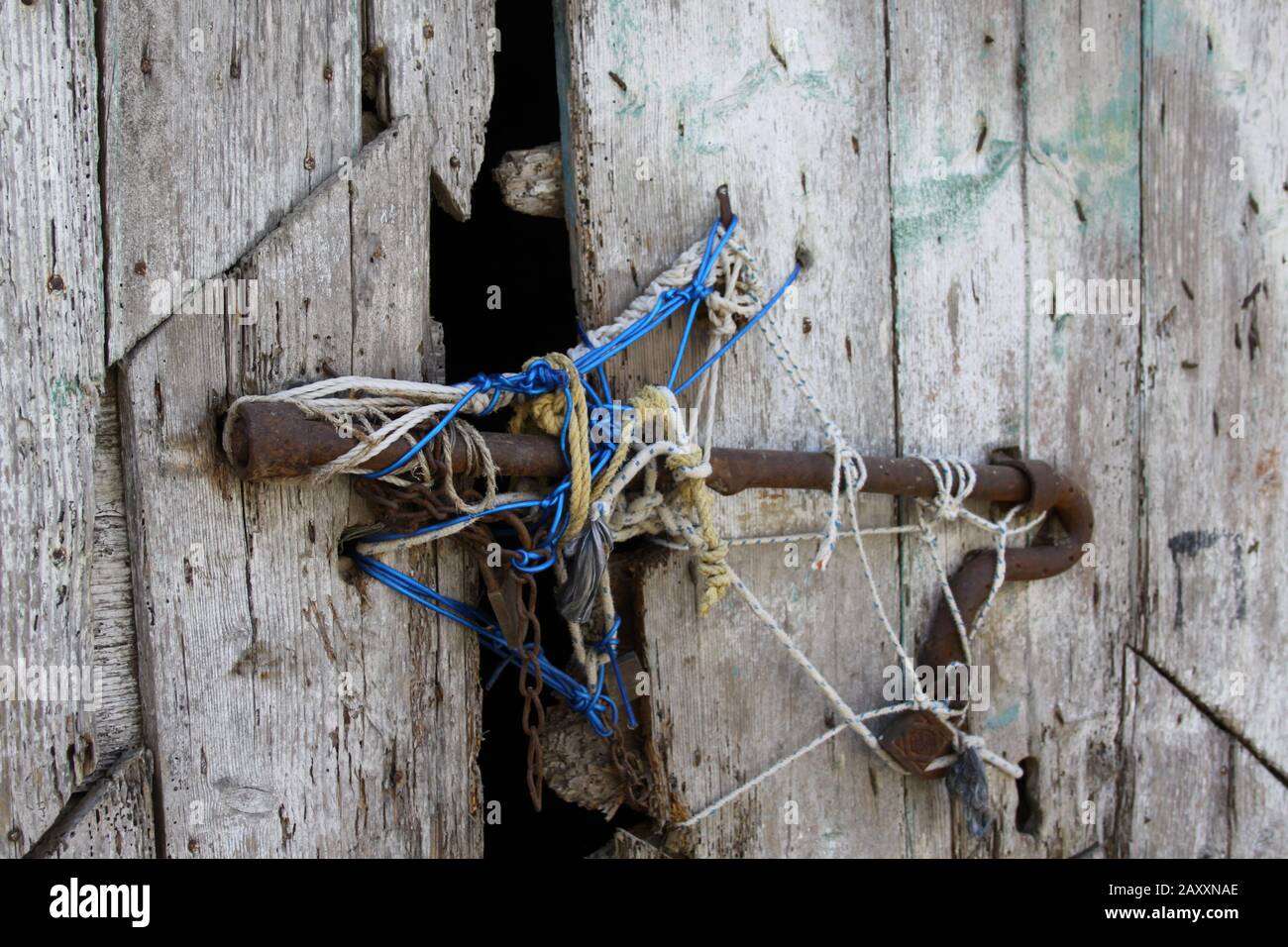 An old lock with nylon rope keeps a door closed Stock Photo - Alamy