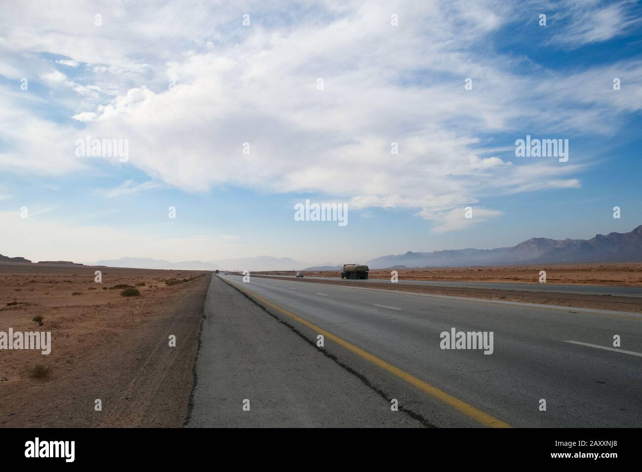 road through the desert landscape. several cars are driving along the ...