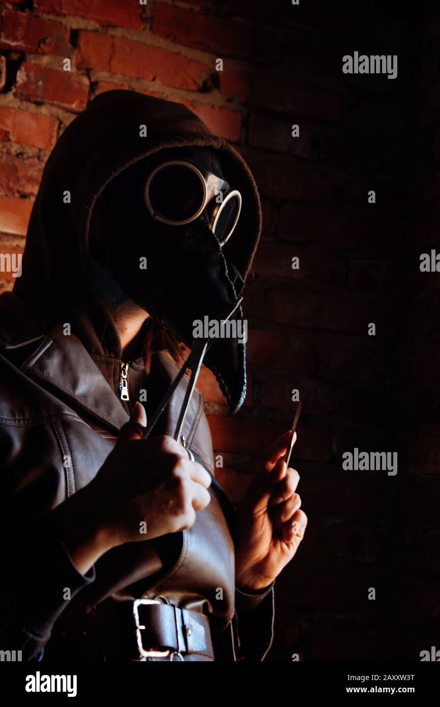 Terrible plague doctor on red brick background. Masked maniac with ...