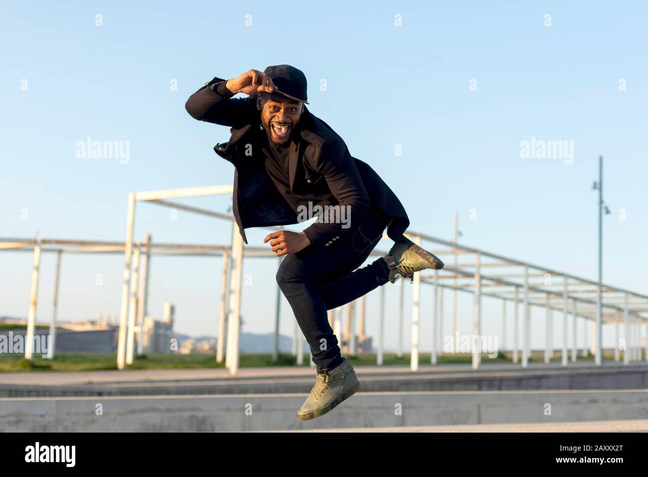 young male dancer in fashionable black clothes dancing blake dance on a ...