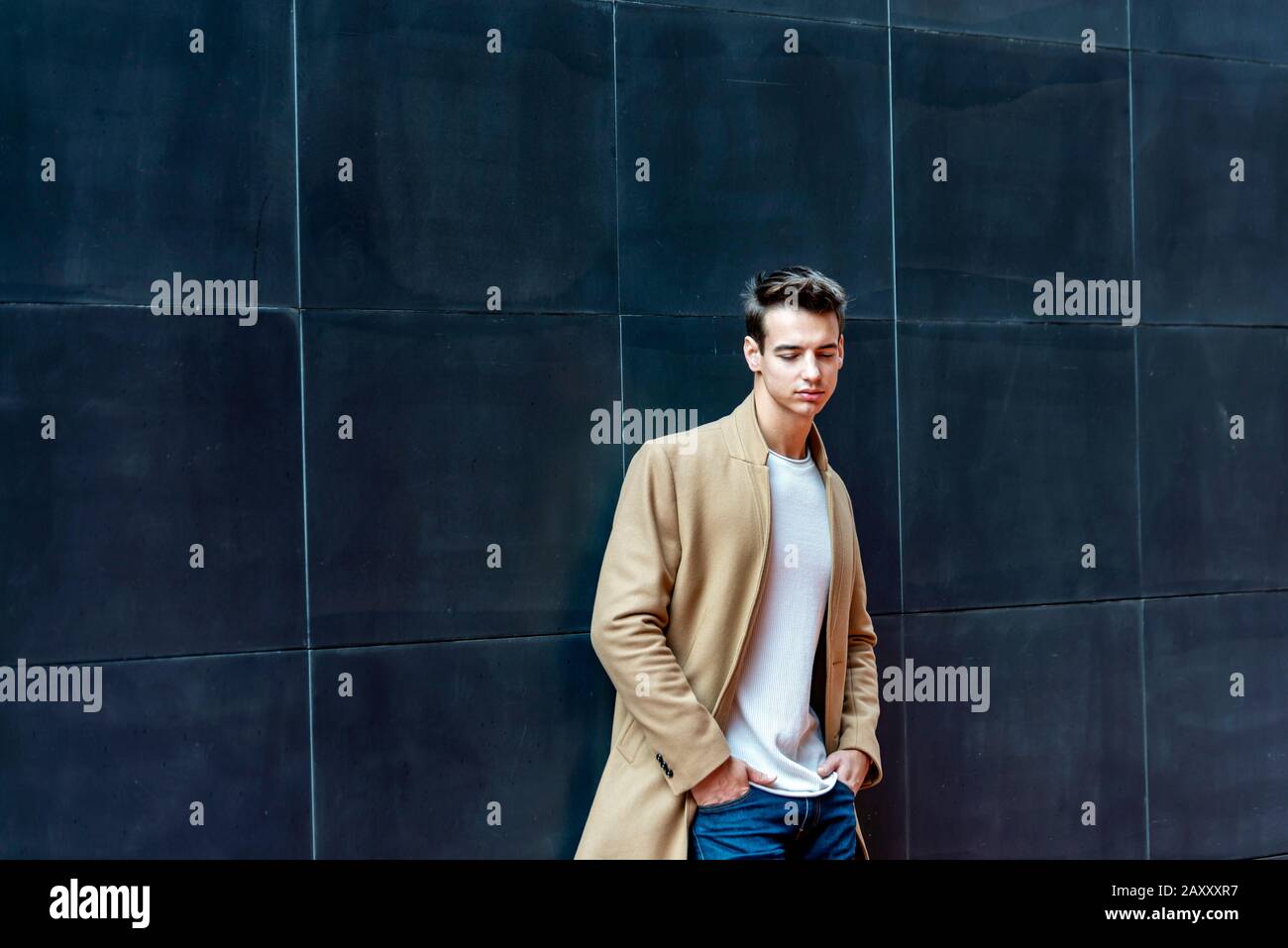 Young man wearing winter clothes in the street. Young guy with modern ...