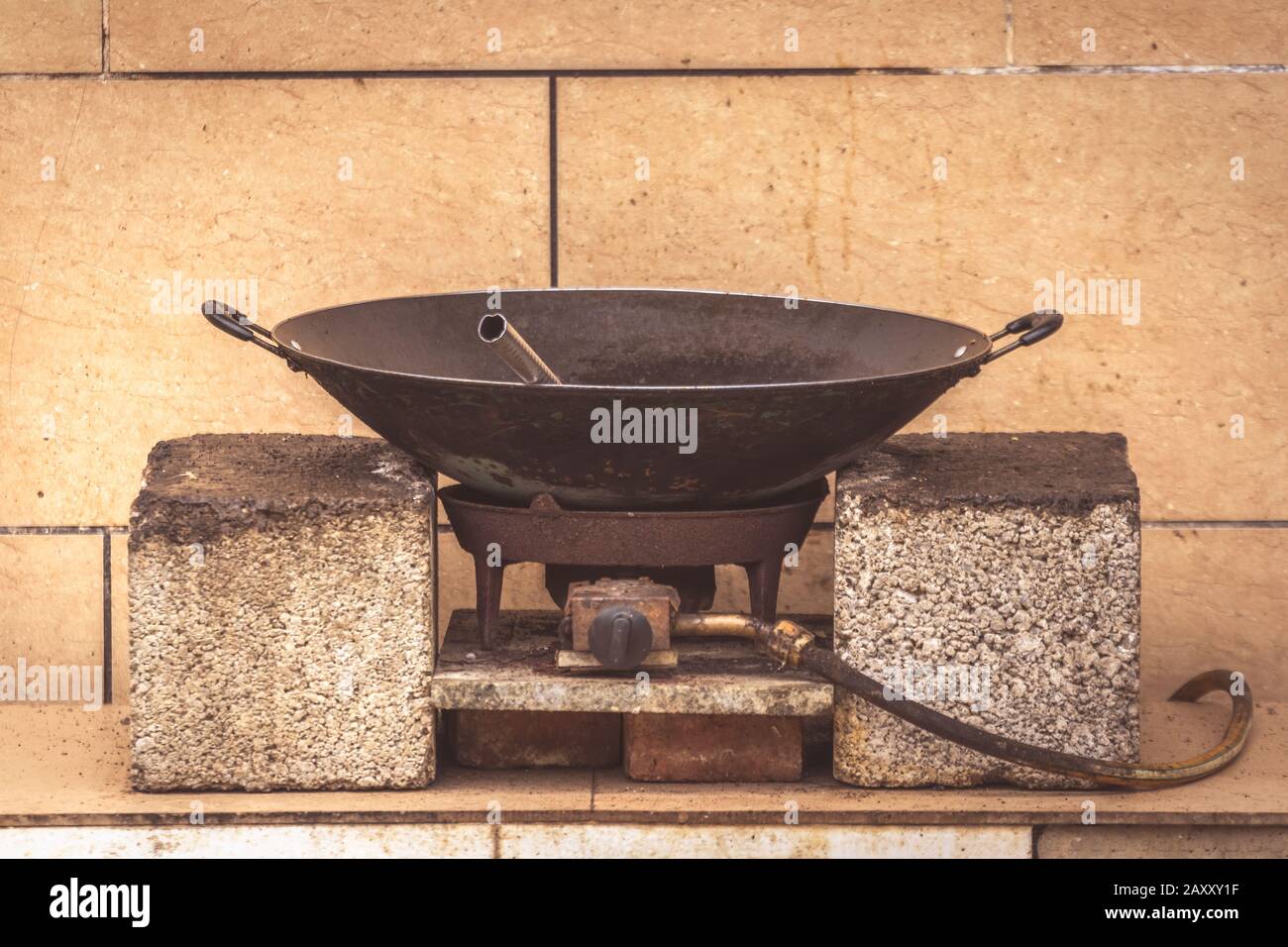 Old black metal pan wok on a gas cooker on a street food stall in China ...