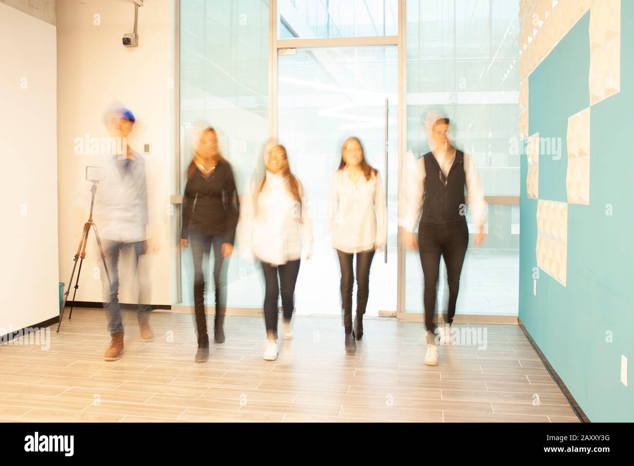 Women and men co-workers moving in the office walking while moving on ...