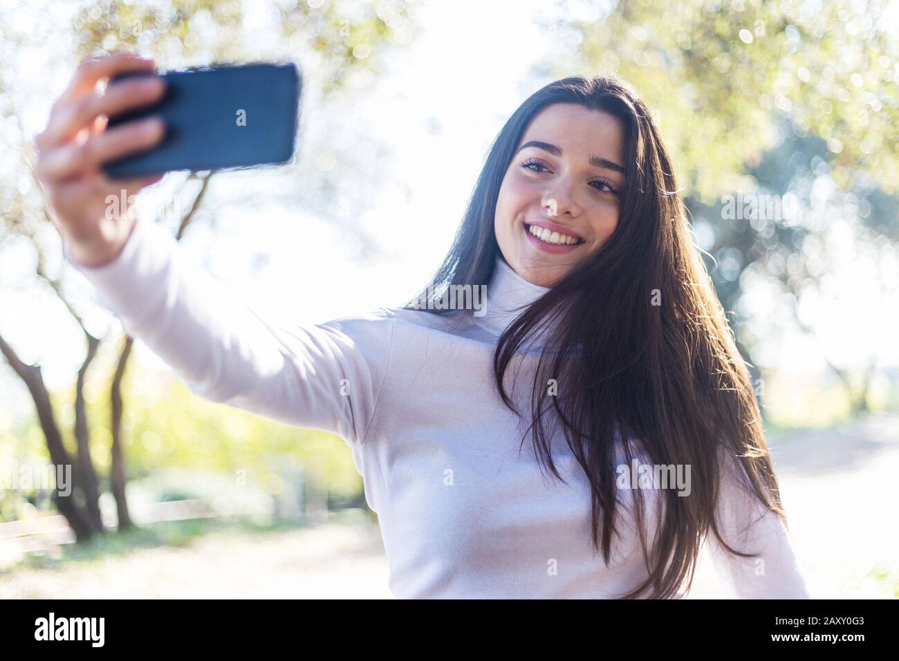 Beautiful young woman taking a self portrait Stock Photo - Alamy