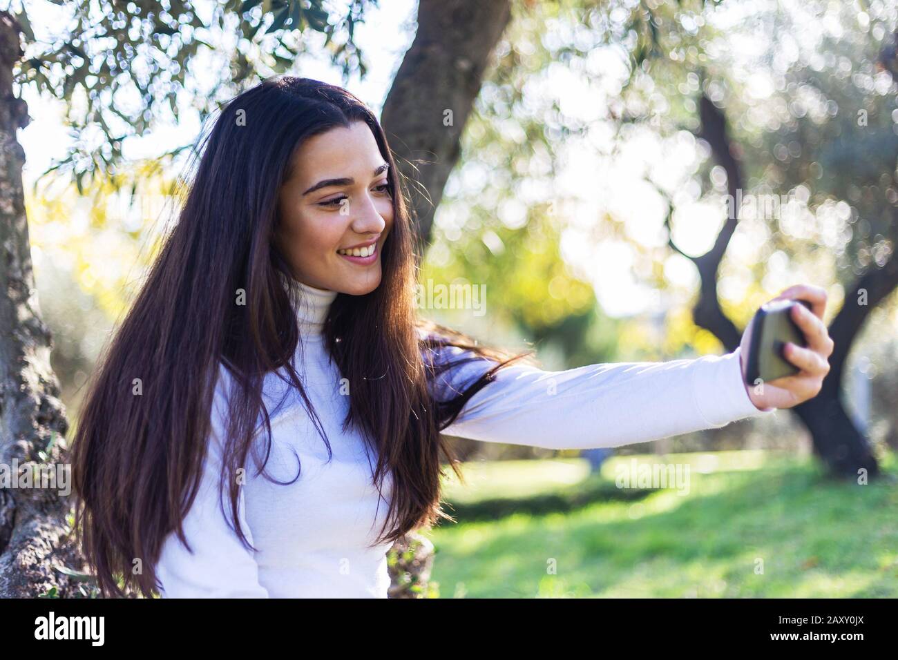 Beautiful young woman taking a self portrait Stock Photo - Alamy