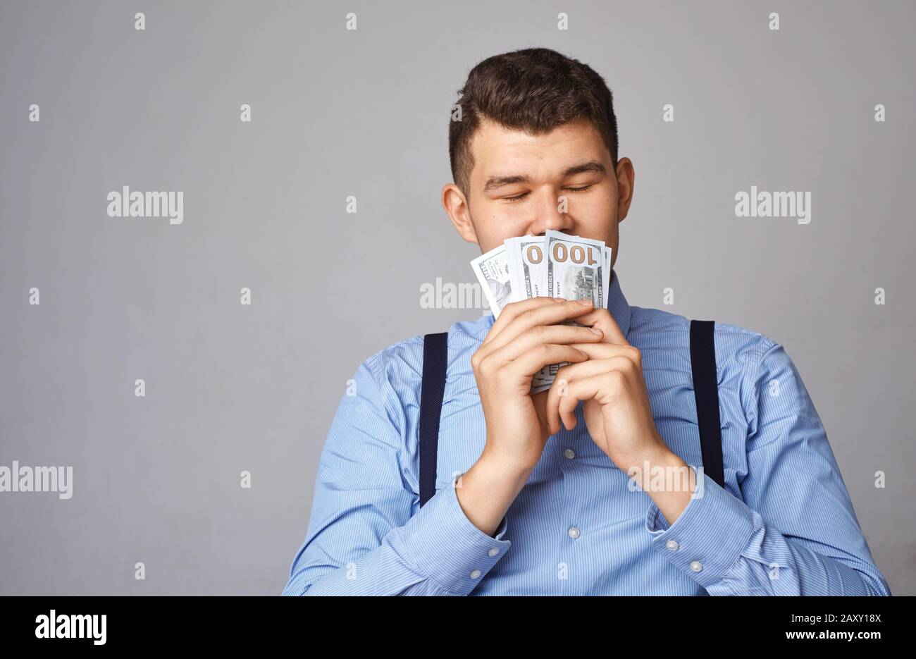 man sniffs money in his hands Stock Photo - Alamy