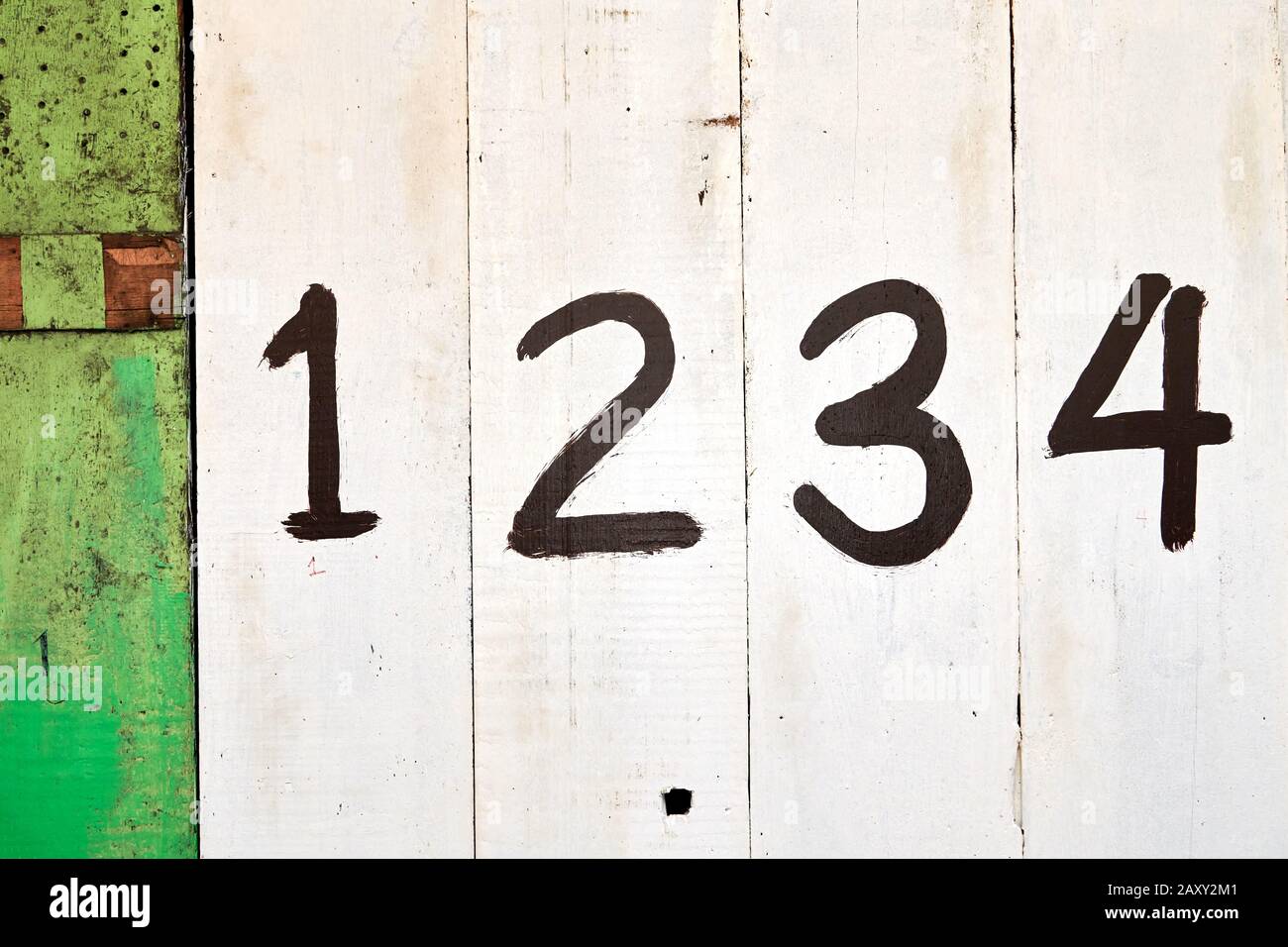 The entrance of a shop is closed with white and green painted wooden ...