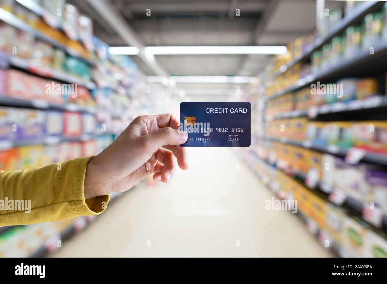 A woman hold a credit card with the supermarket background, Easy to ...