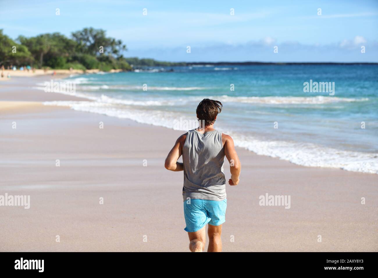 Man athlete running away from behind on beach at sunset. Male runner ...