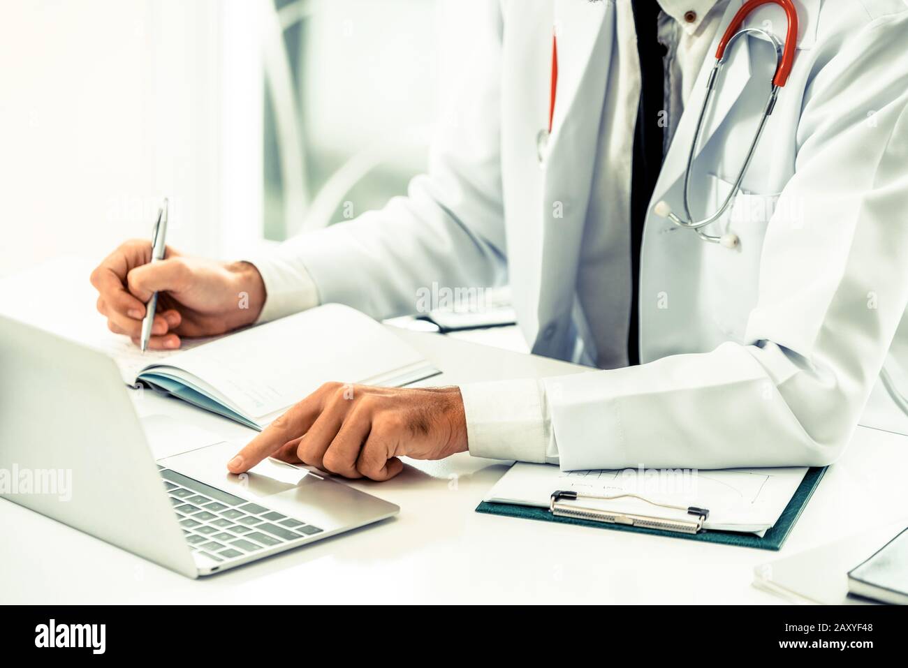 Doctor working on laptop computer at office table in the hospital ...