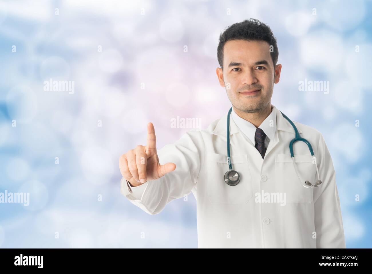 Male doctor pointing finger at copy space, standing in hospital ...