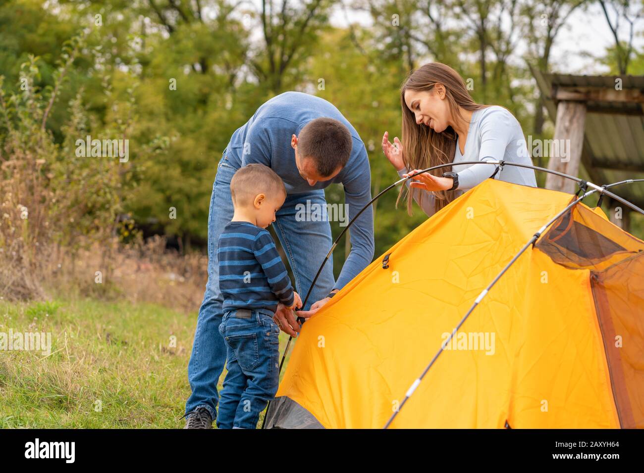 Happy family with little son set up camping tent. Happy childhood ...