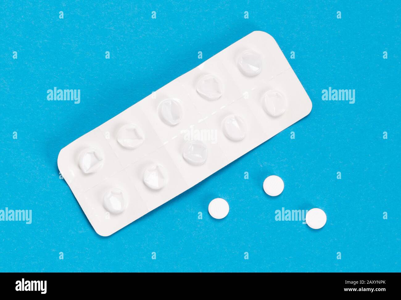 Pill strip isolated on a blue background Stock Photo - Alamy