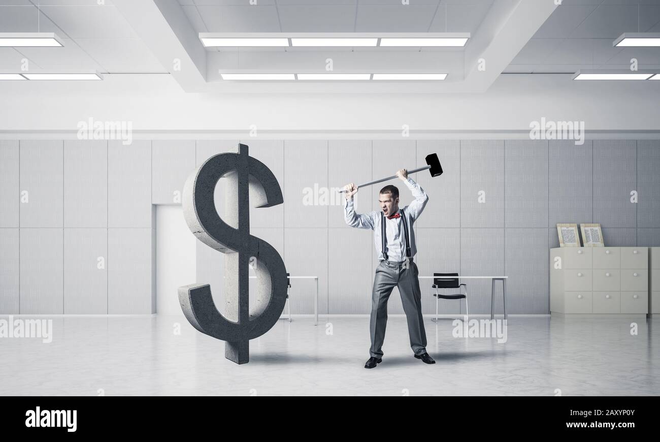 Determined banker man in modern office interior breaking dollar figure ...