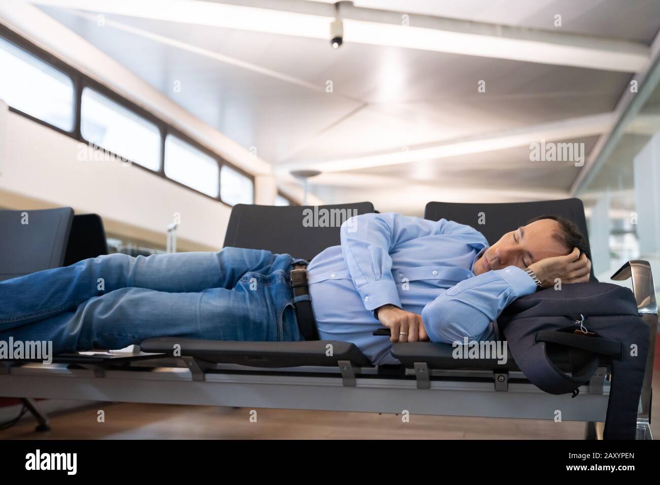 Delayed Flight. Man Sleeping In Airport Terminal Stock Photo - Alamy