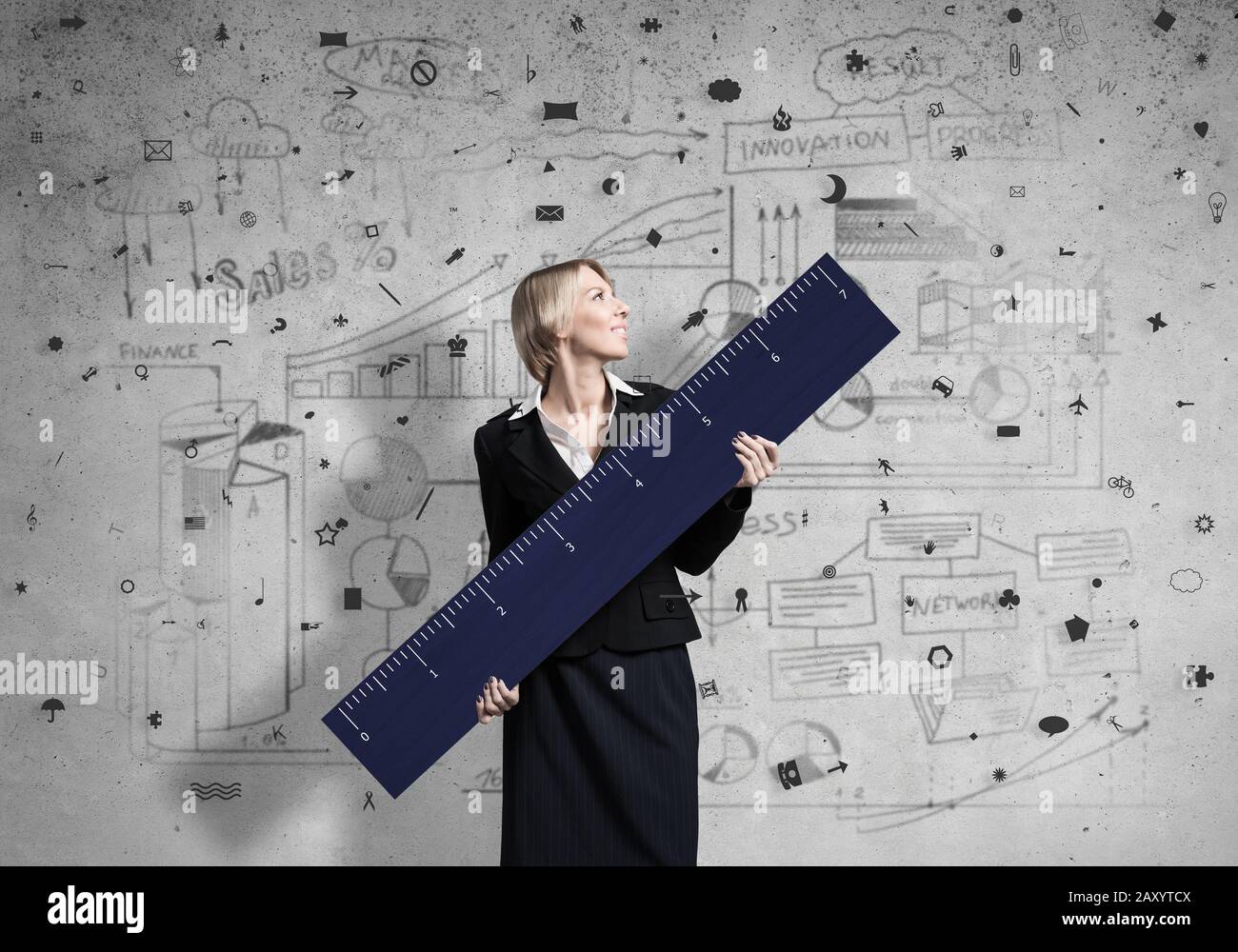 Woman in business suit holding big ruler Stock Photo - Alamy
