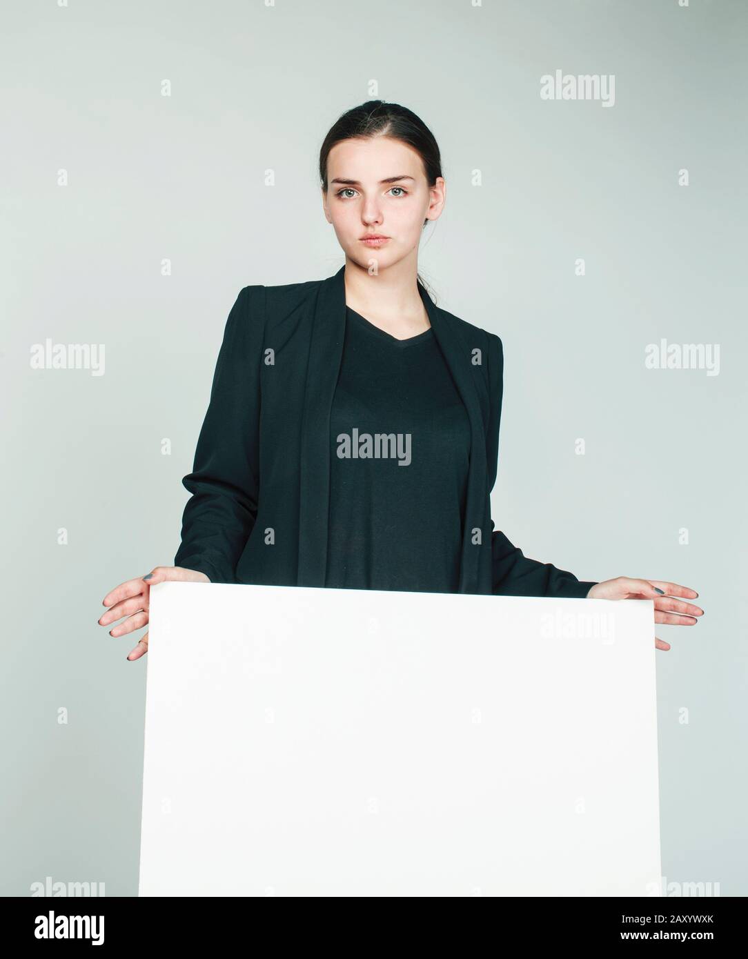 young pretty brunette girl with placard on white background wearing ...