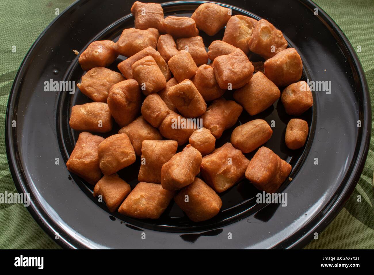 close up photo of small maandazi on a black dinner plate Stock Photo ...