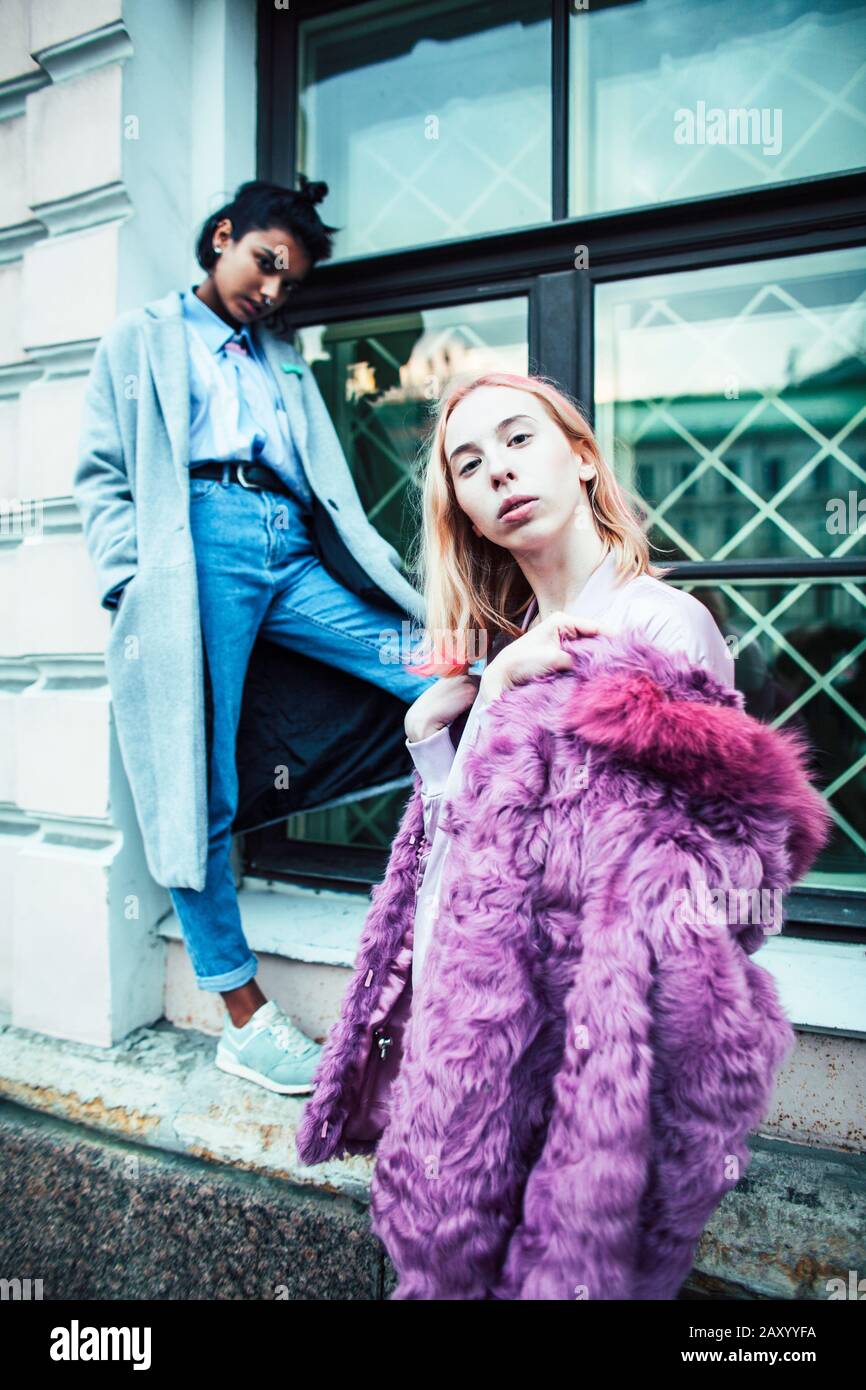 Two teenage girls infront of university building smiling, having fun ...