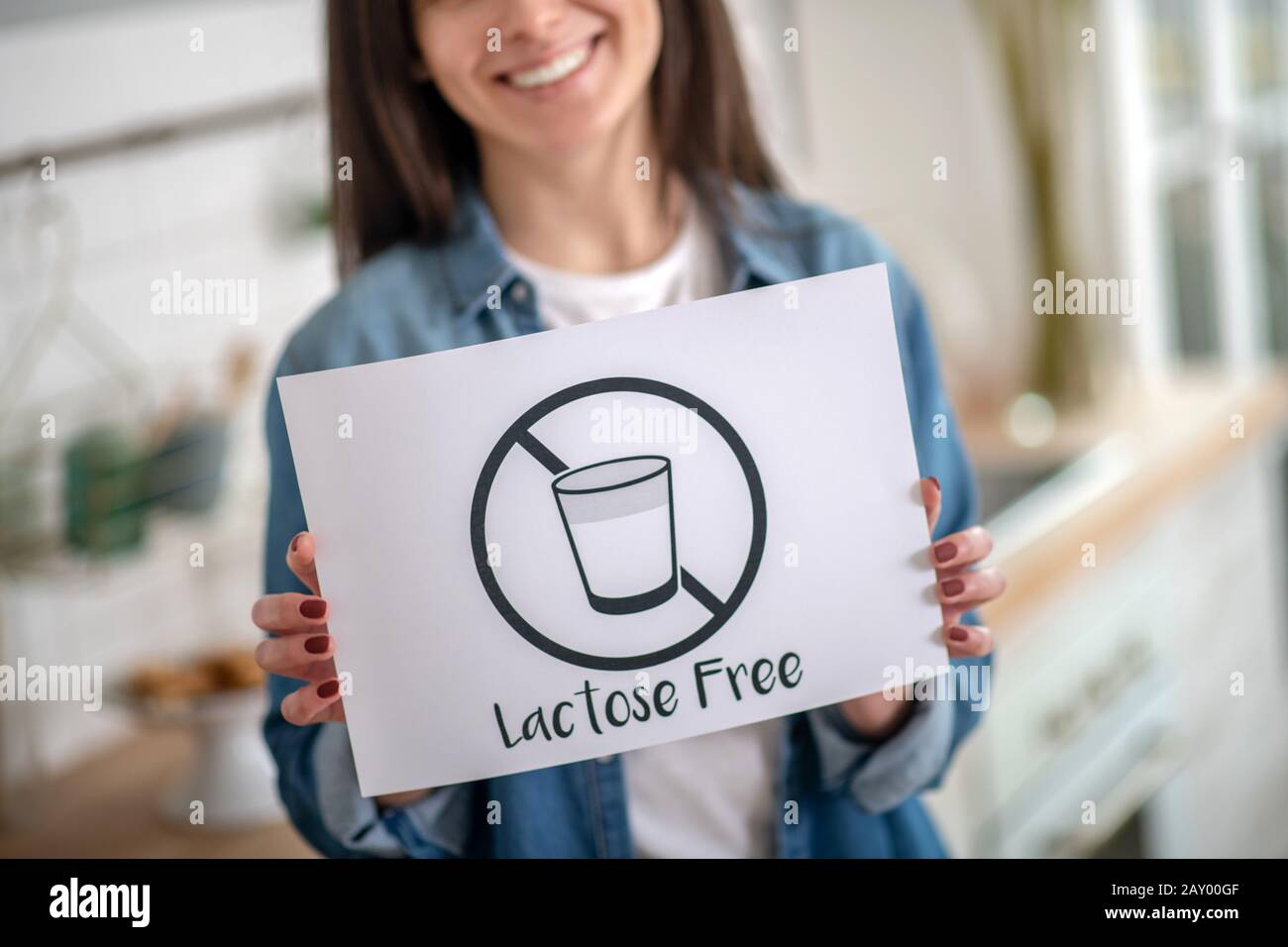 Woman holding a lactose free paper sign Stock Photo - Alamy