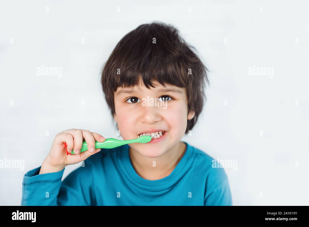 Little boy brushing his teeth on white background. little child cleans ...