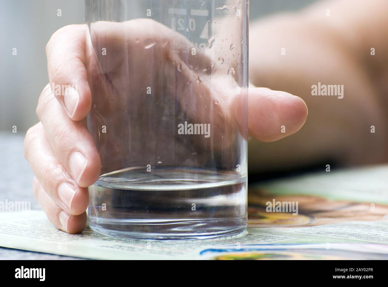 Hand holding water glass Stock Photo - Alamy