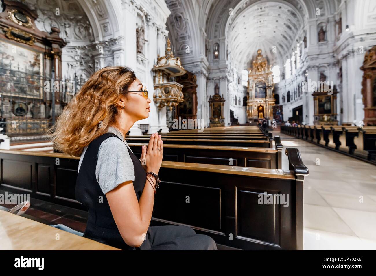 Alone woman praying in church Stock Photo - Alamy