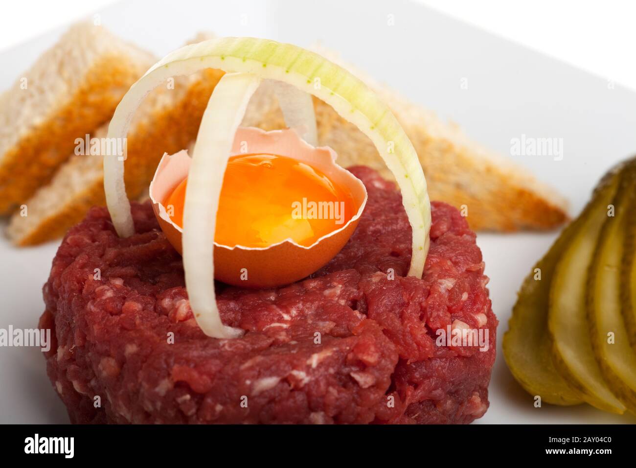 Tatar with onion rings and open egg Stock Photo - Alamy