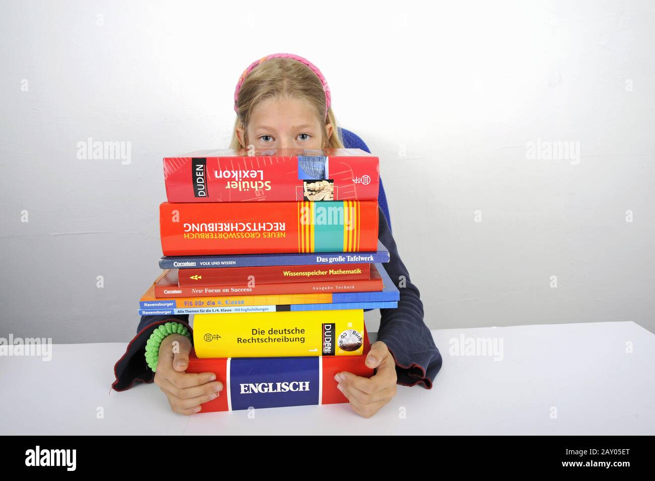 young student behind a pile of books, school stress Stock Photo - Alamy