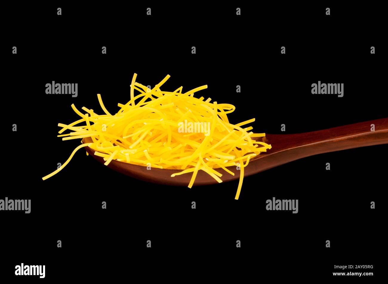 Spaghetti in wooden spoon isolated on black Stock Photo - Alamy