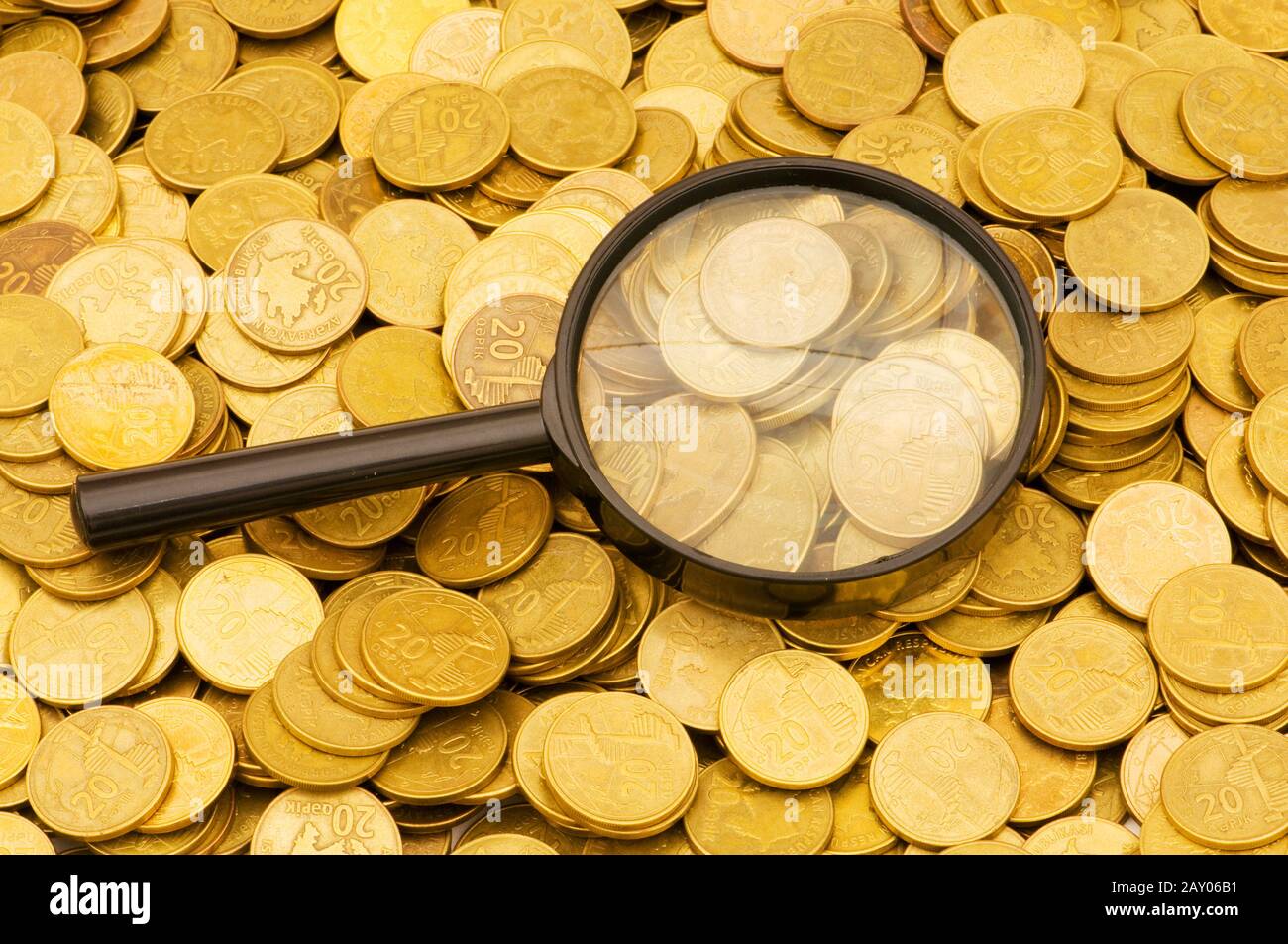 Magnifying glass and lots of gold coins Stock Photo - Alamy