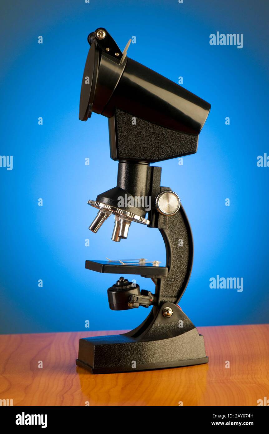 Microscope against blue gradient background Stock Photo - Alamy