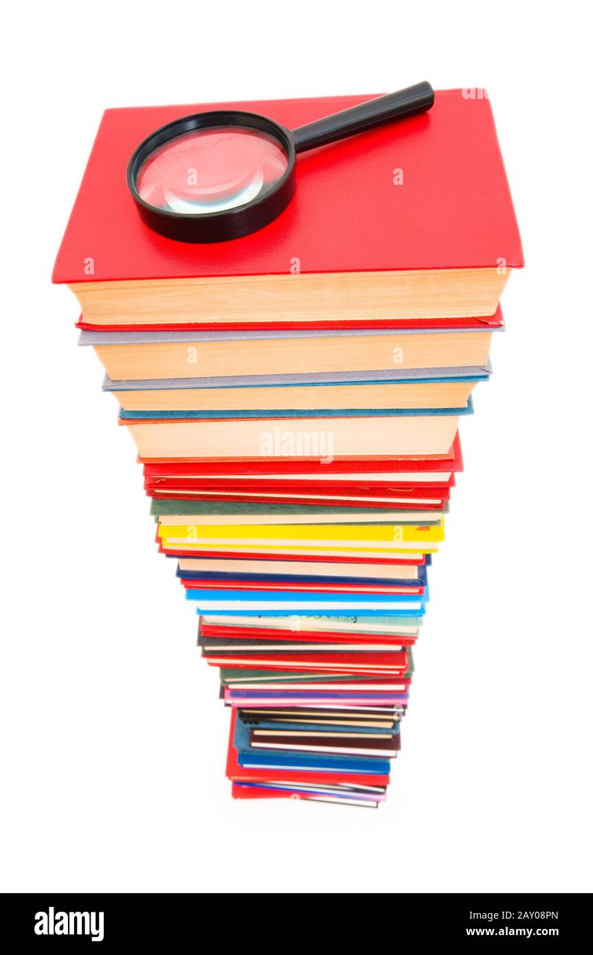 Magnifying glass over the stack of books Stock Photo - Alamy