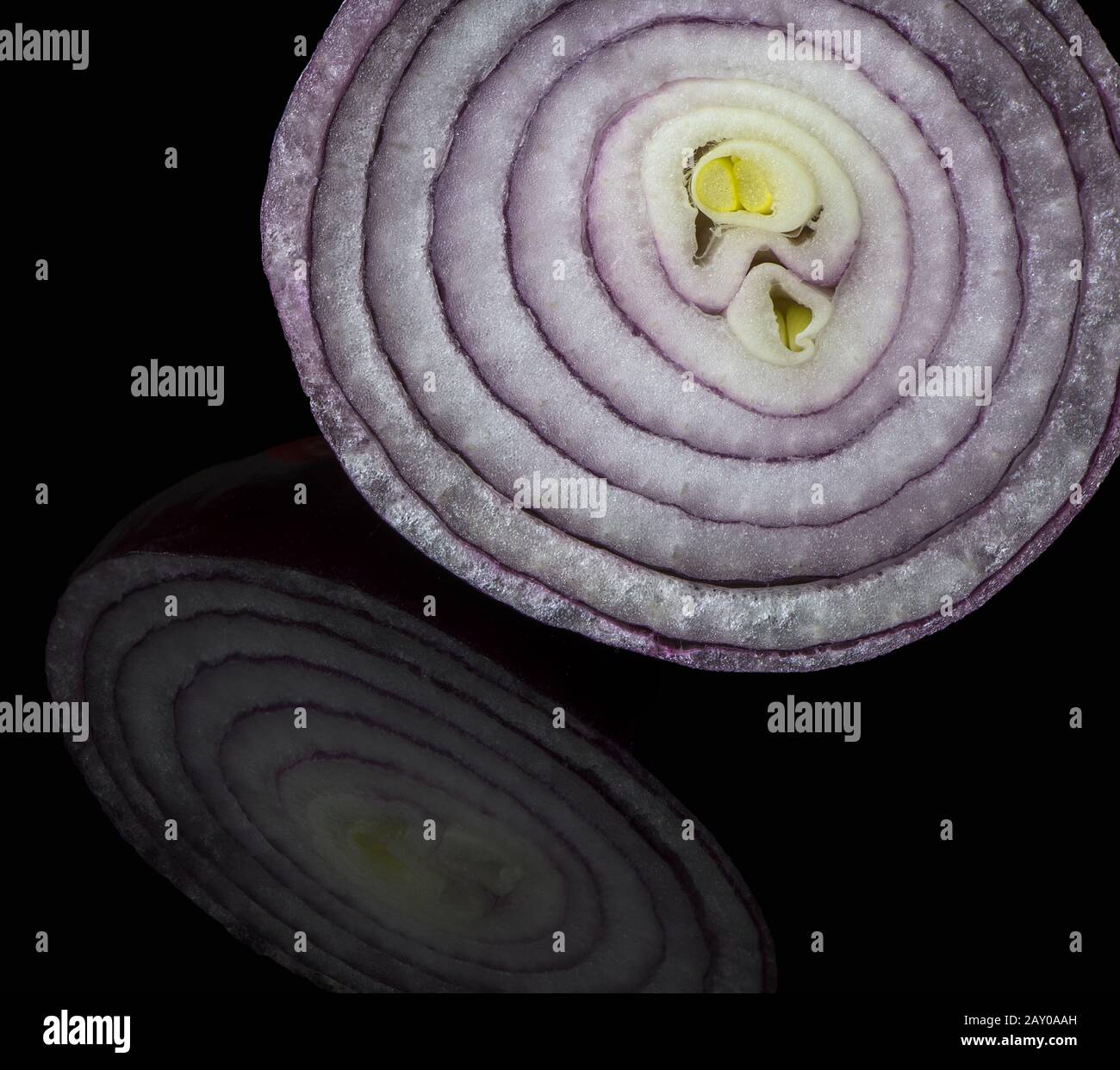 half of a big red onion in detail with reflection on black background ...