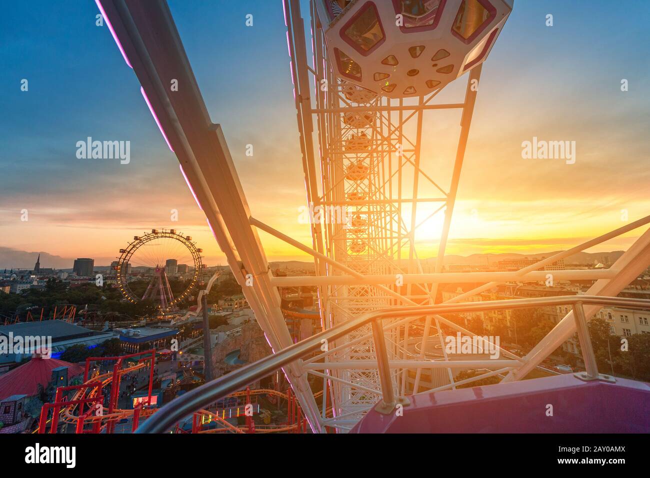 Aerial view of amusement park at sunset with ferris wheel and roller ...