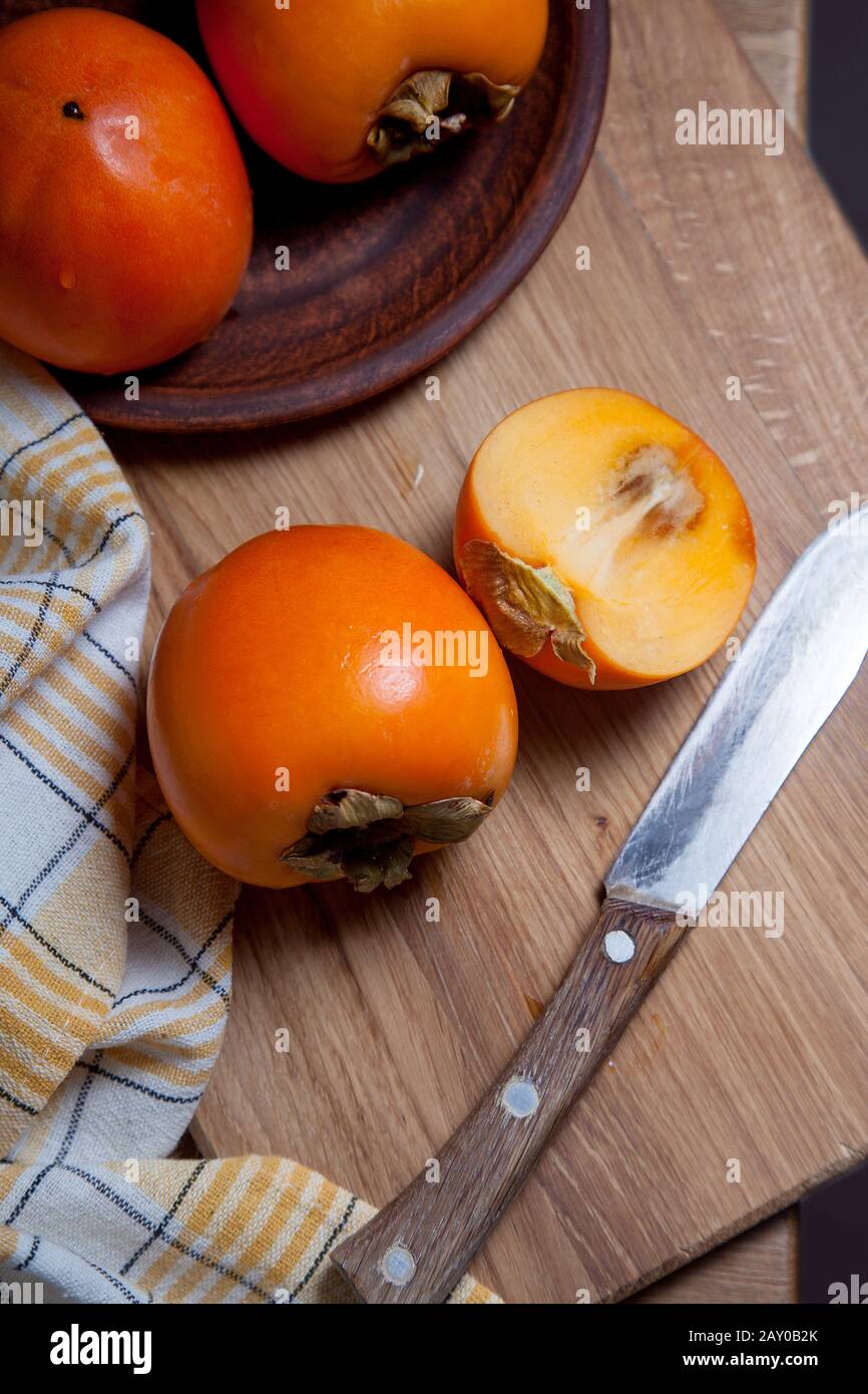 Composition of ripe delicious whole persimmon fruits, half and sliced ...