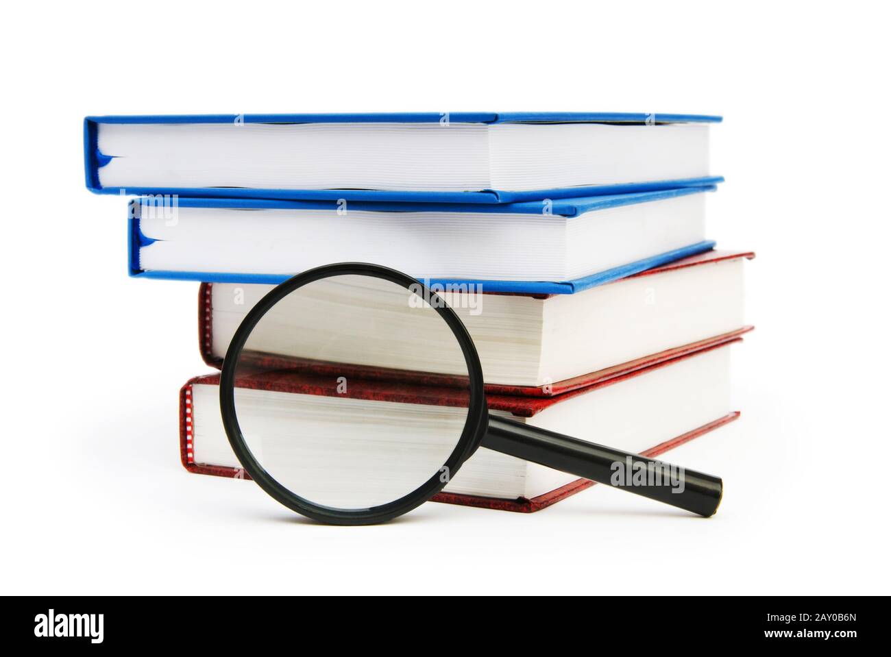 Magnifying glass over the stack of books Stock Photo - Alamy