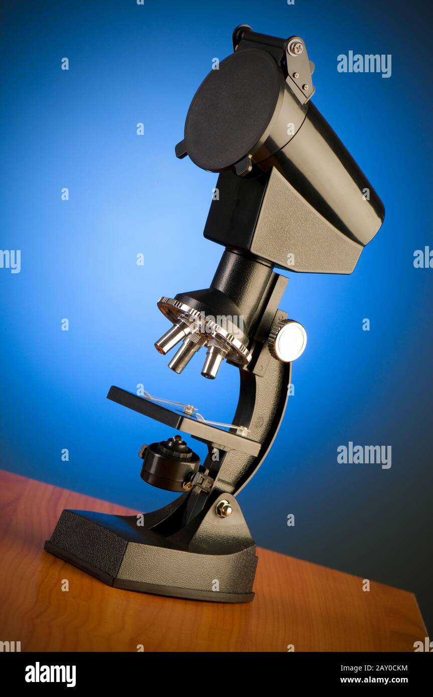 Microscope against blue gradient background Stock Photo - Alamy
