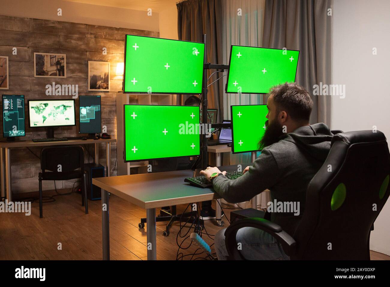 Back view of hackers in front of computer with multiple screens with ...