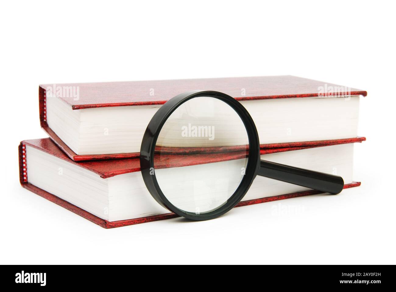 Magnifying glass over the stack of books Stock Photo - Alamy