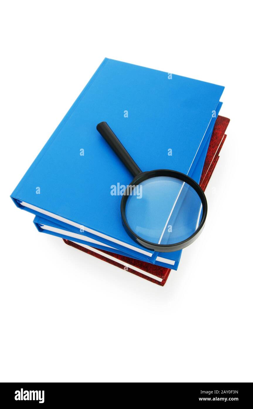 Magnifying glass over the stack of books Stock Photo - Alamy