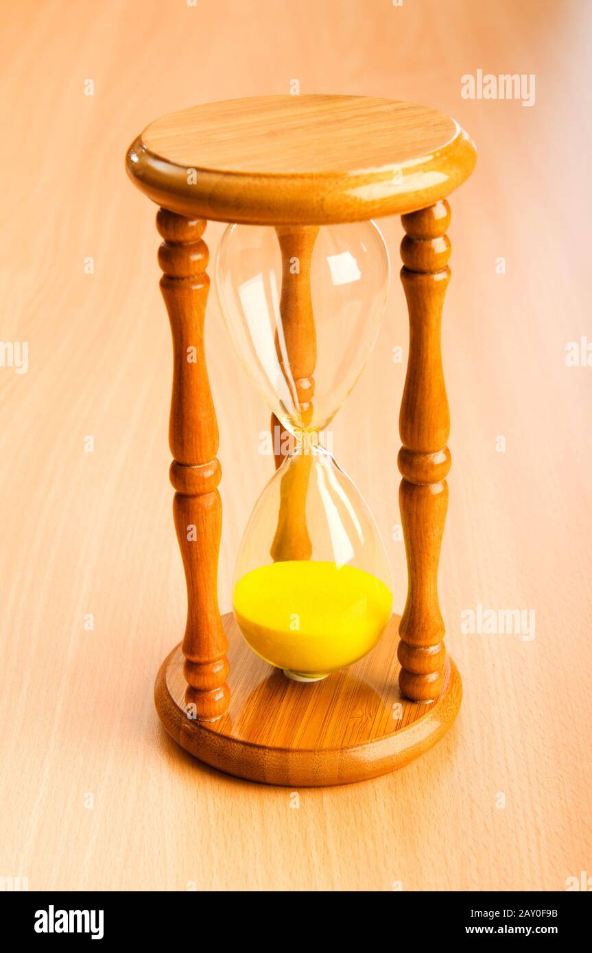 Time concept with hourglass on wooden background Stock Photo - Alamy