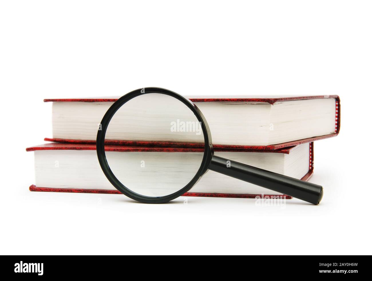 Magnifying glass over the stack of books Stock Photo - Alamy