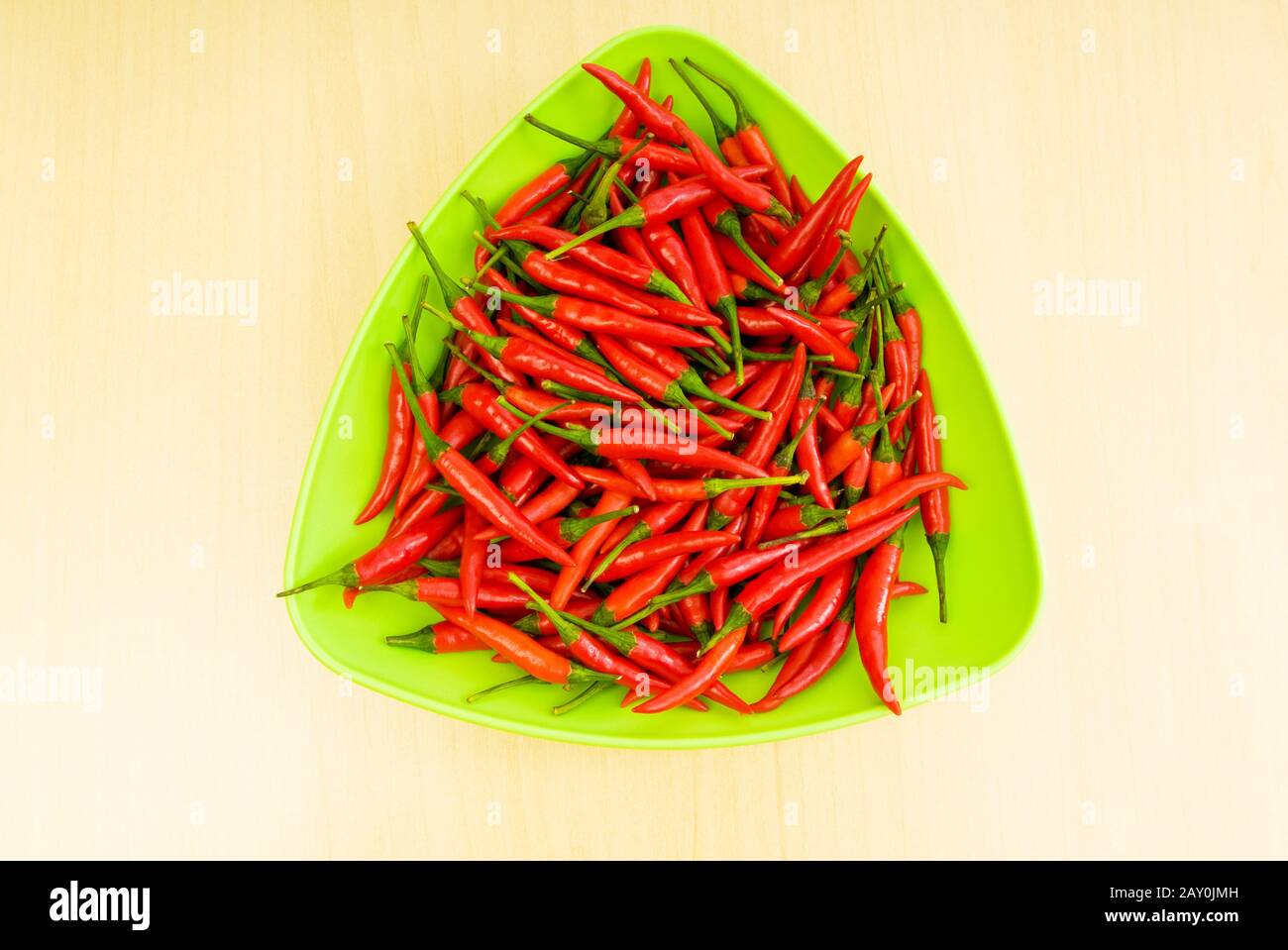 Hot peppers in the plate on wooden table Stock Photo - Alamy