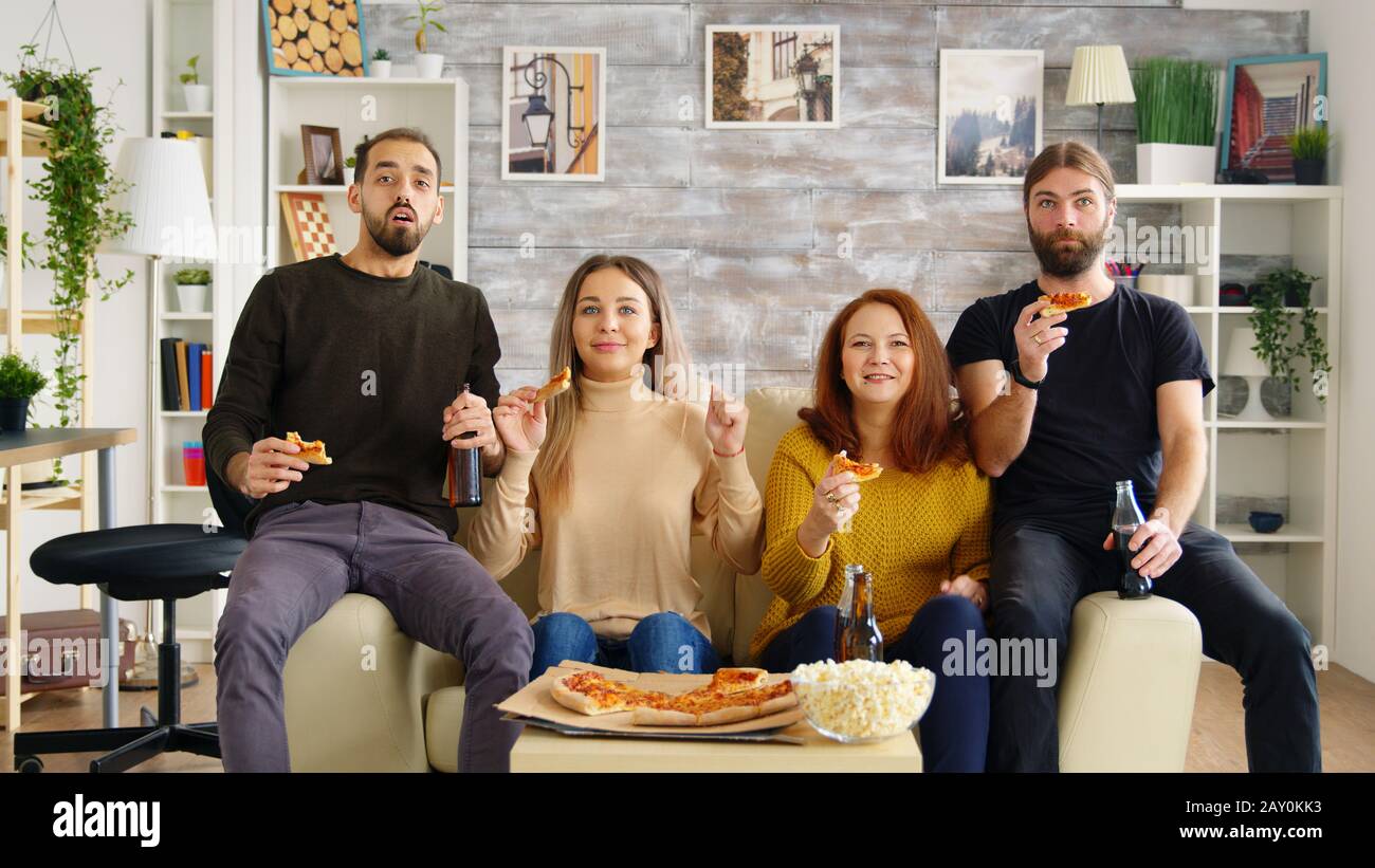 Group of friends relaxing together in living room playing video games ...