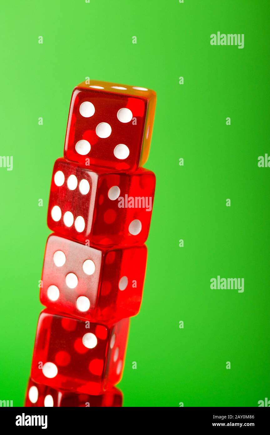 Red dice stack against blurred green background Stock Photo - Alamy