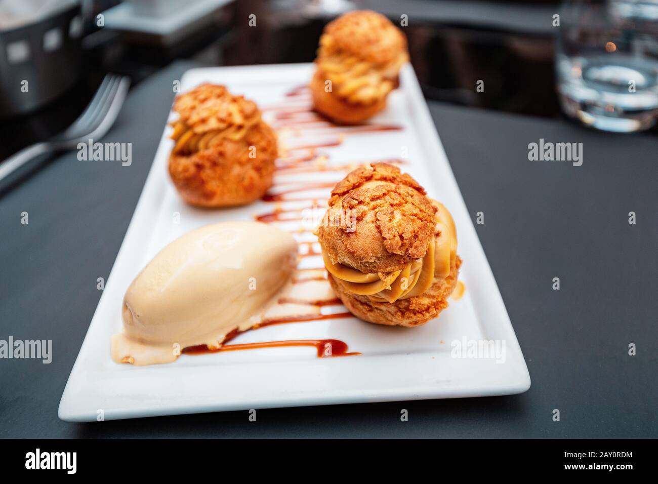 Delicious Profiteroles dessert on a plate in restaurant Stock Photo - Alamy
